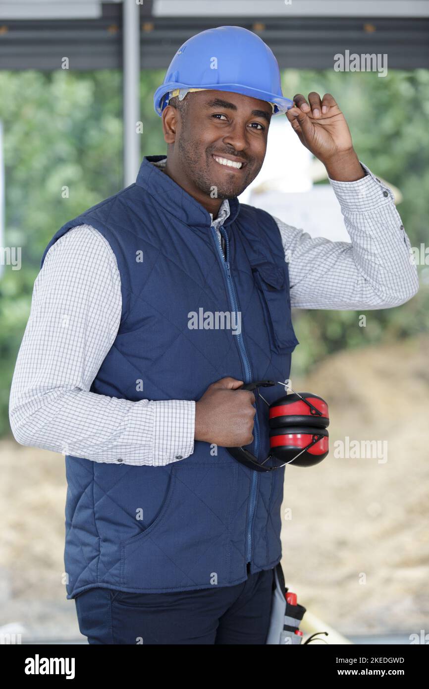 smiling workman tipping his safety helmet Stock Photo - Alamy
