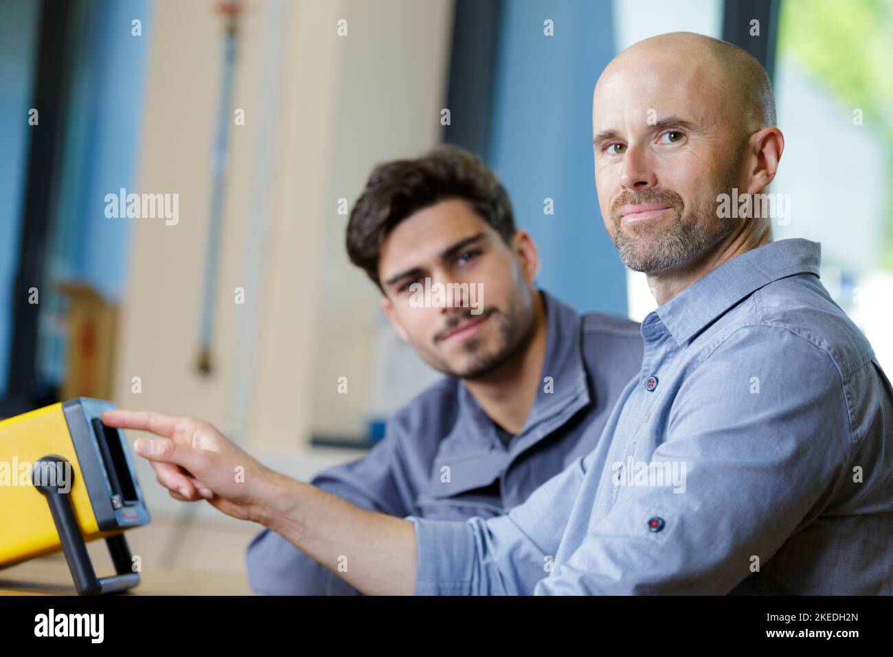 two men operating a machine Stock Photo - Alamy