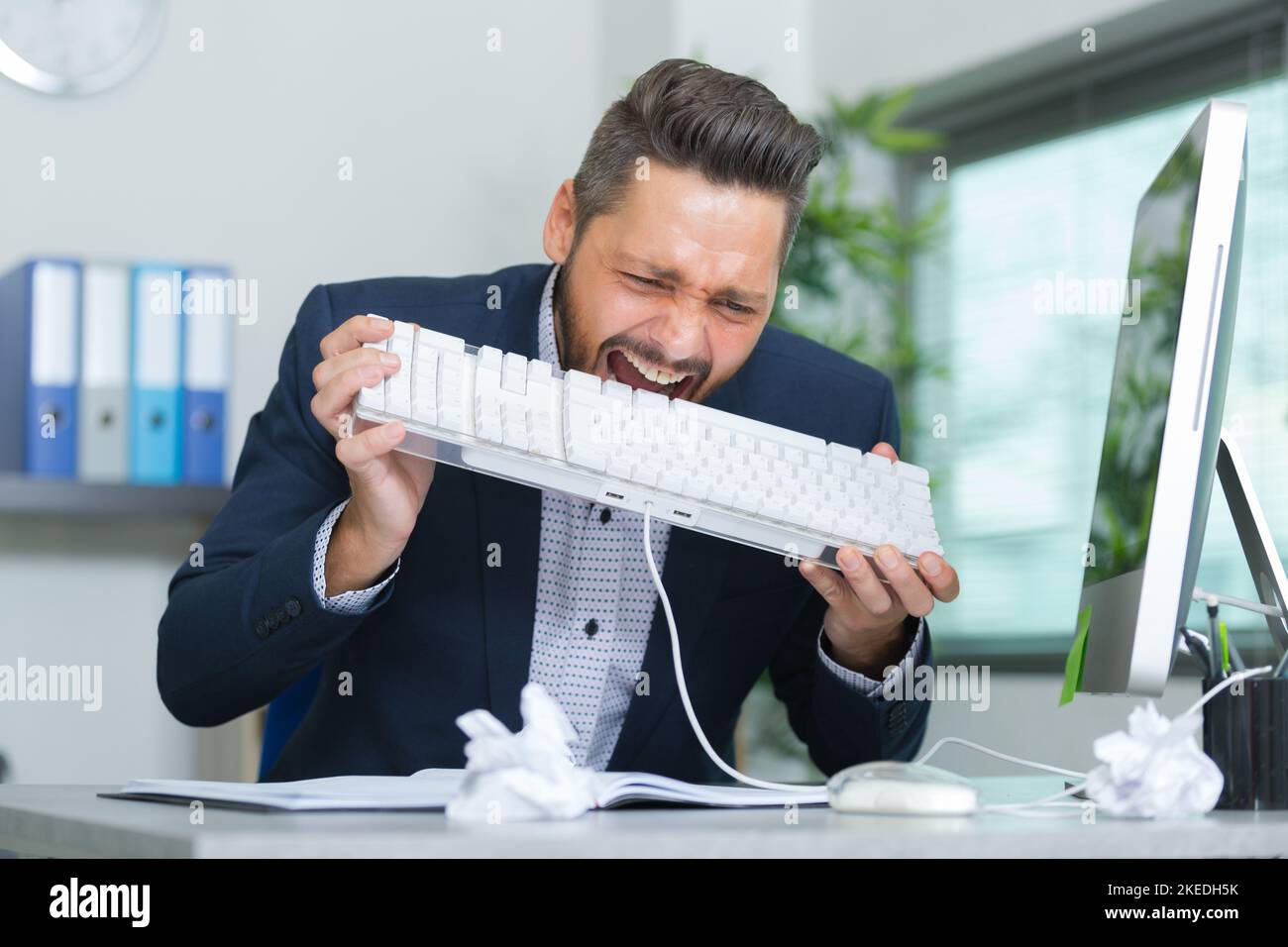 man trying to bite the keyboard Stock Photo - Alamy