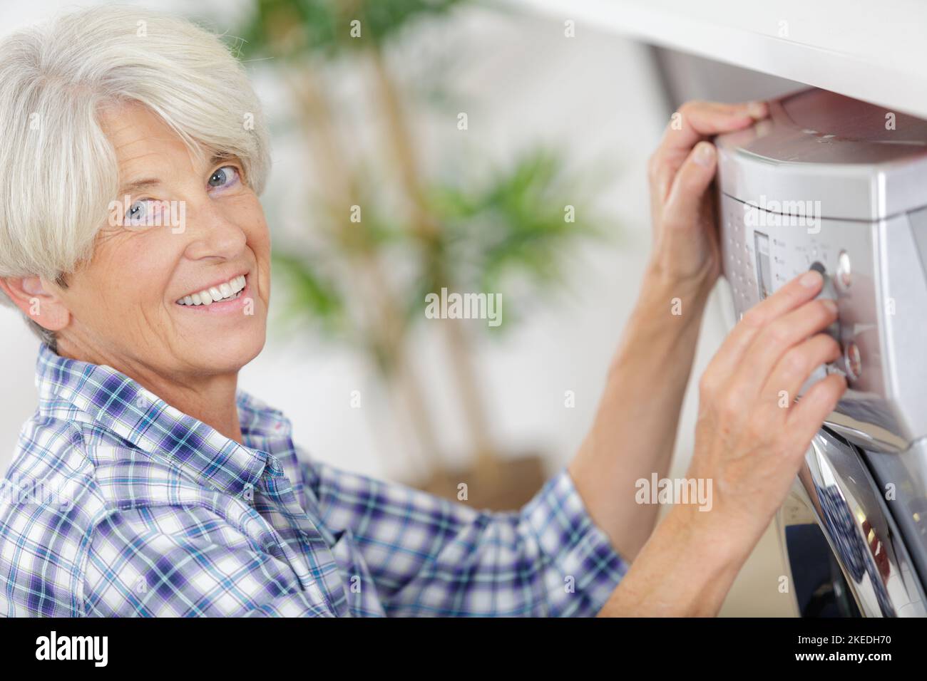 Woman using washing machine hi-res stock photography and images - Alamy