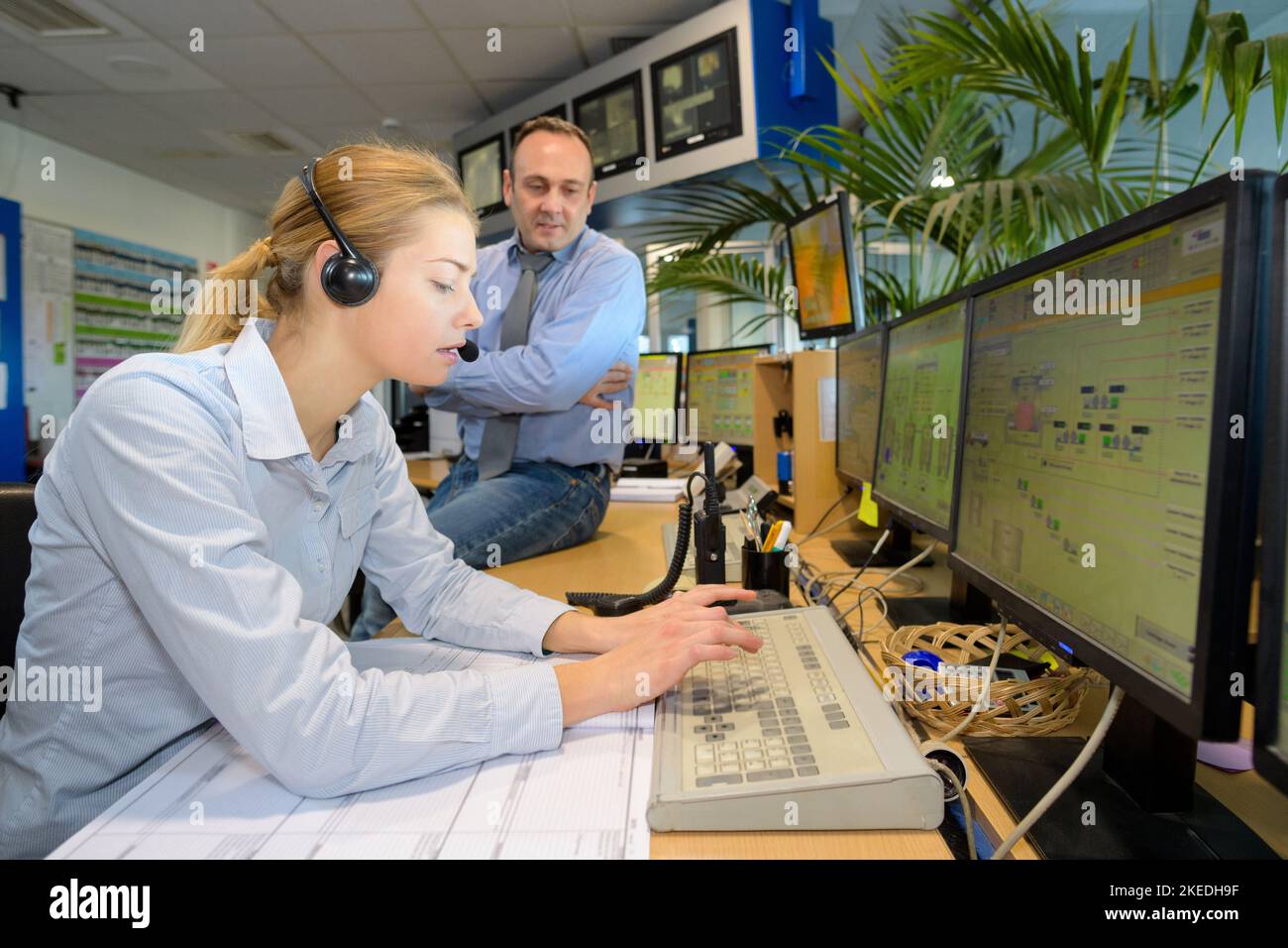 woman wearing headset and typing in control center Stock Photo - Alamy