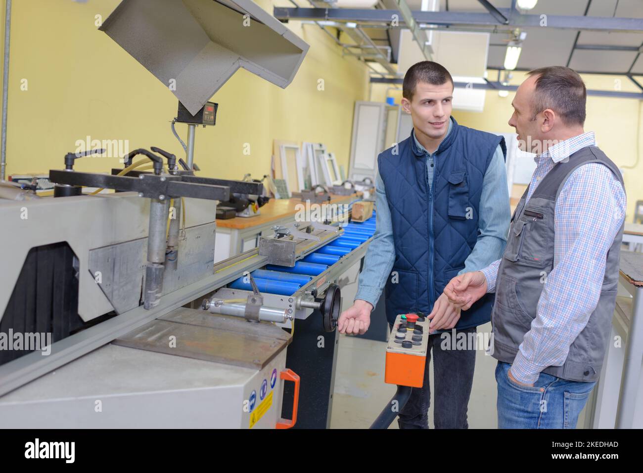 two men stood by factory producation line Stock Photo - Alamy