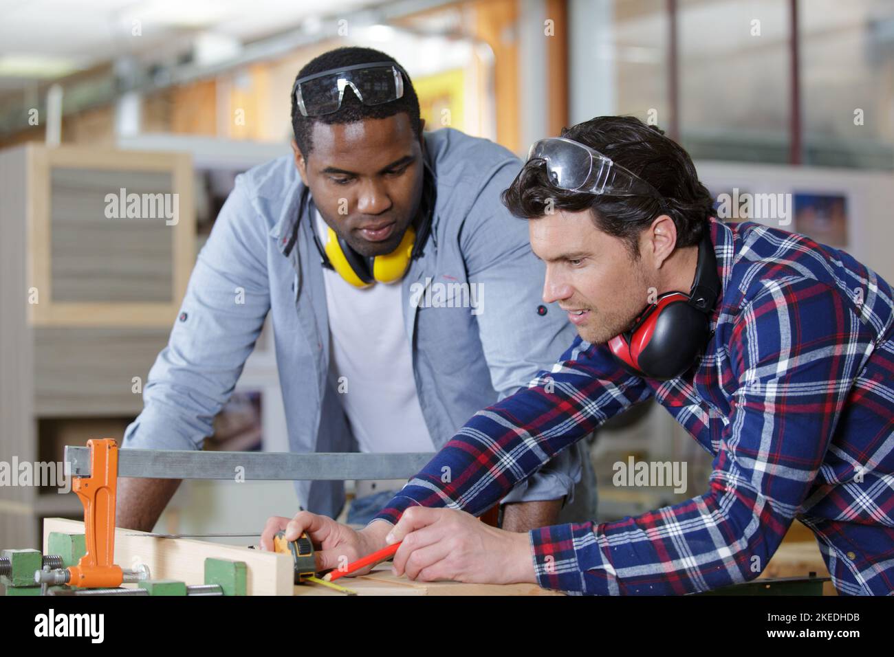 carpenter training male apprentice to use plane Stock Photo - Alamy