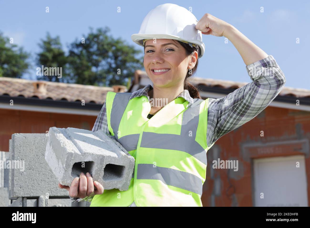 woman builder holding concrete block and flexing her muscles Stock ...
