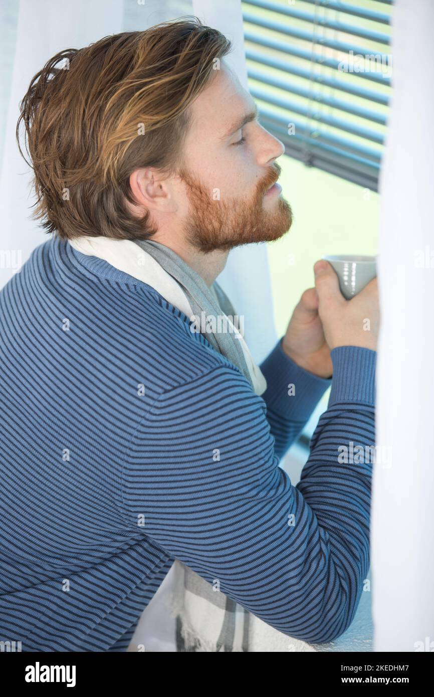 happy young man looking out the window Stock Photo - Alamy