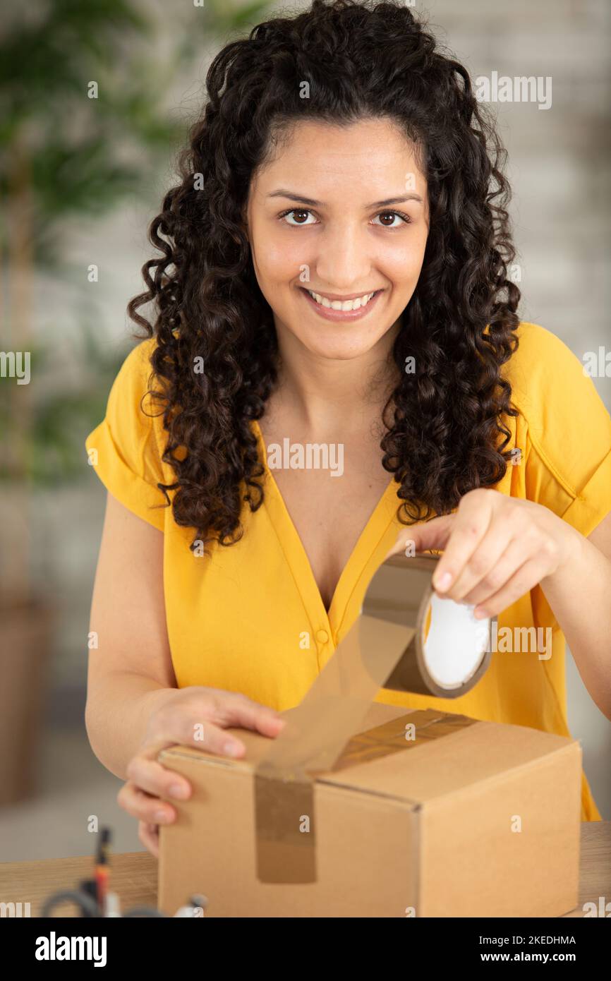 excited young woman packing package Stock Photo - Alamy