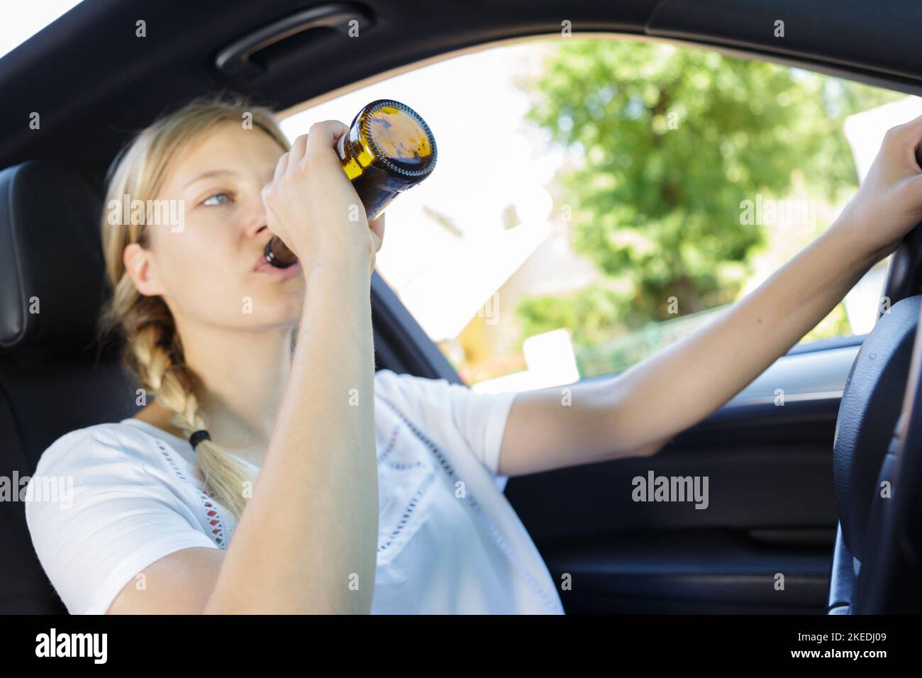 profile of a woman drinking beer while driving her car Stock Photo - Alamy