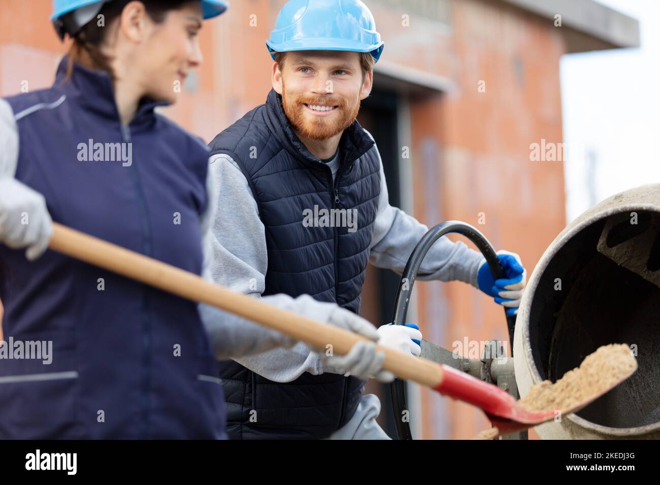 craftsman and female builder making cement Stock Photo - Alamy