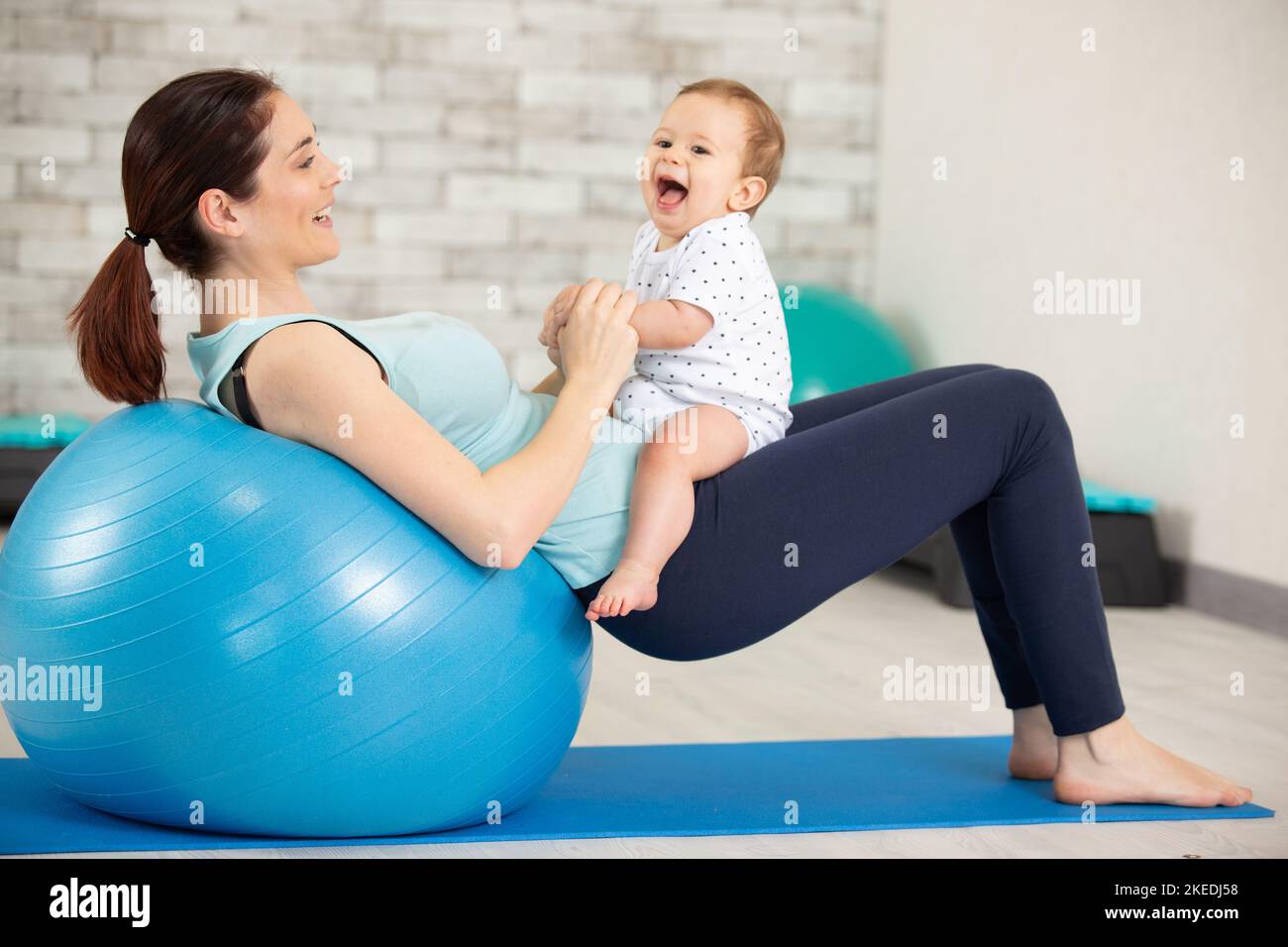 mother is engaged in fitness as she exercises with baby Stock Photo - Alamy