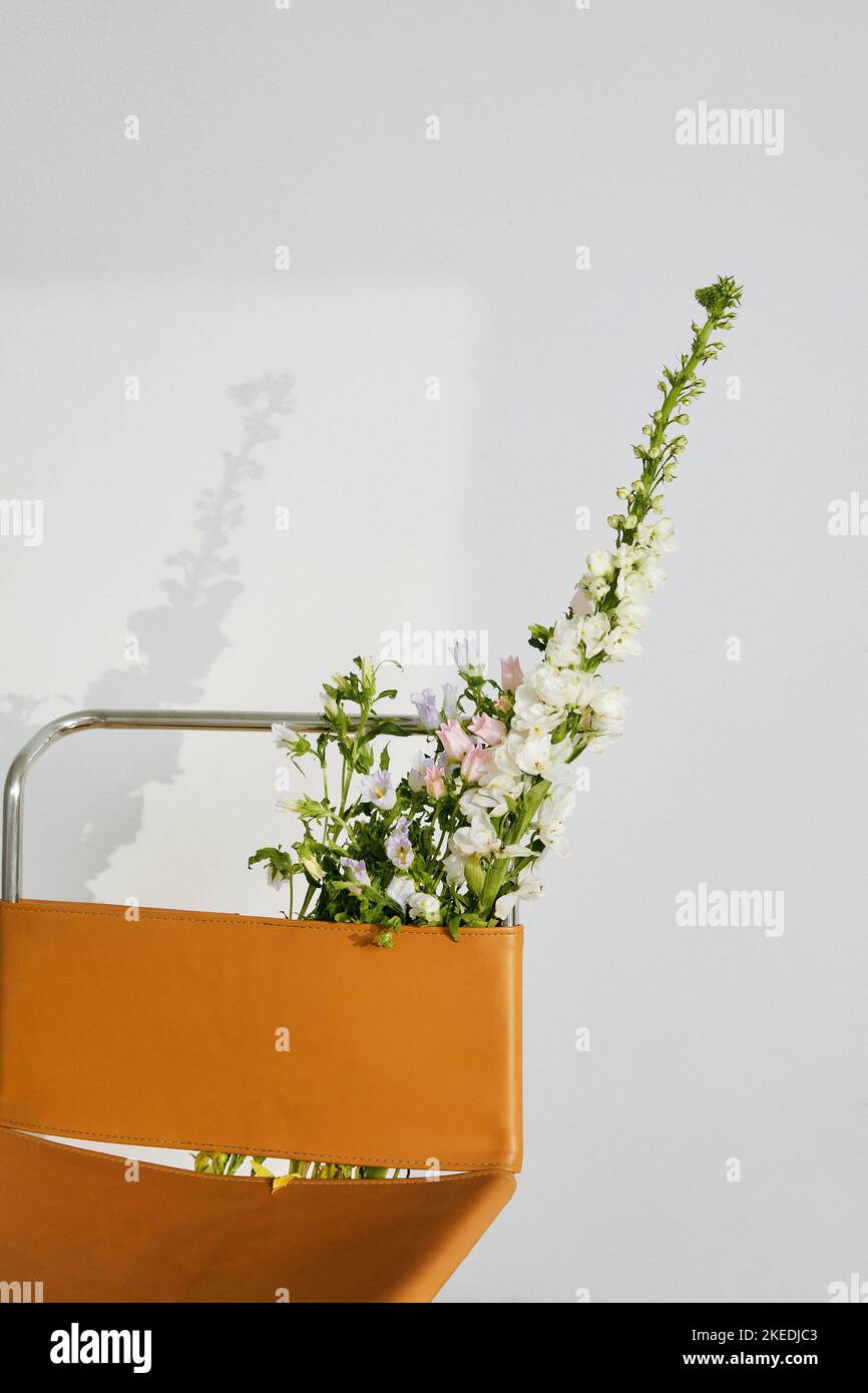 A vertical shot of flowers on a beach chair against a white background ...