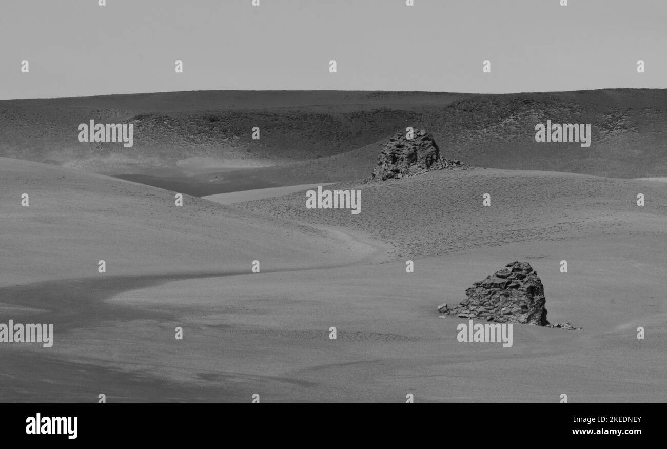 A grayscale shot of sand dunes with rocks in Cordillera, Bolivia Stock ...