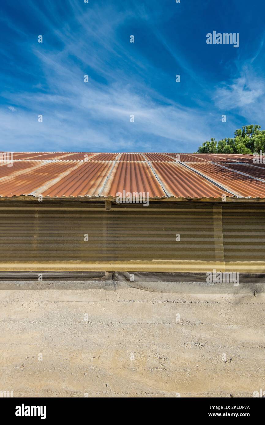 A rusted metal roof with dramatic sky, deep blue with whispy clouds in ...