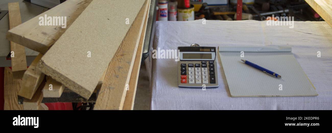 Image of a workbench in a workshop with a calculator, notepad, and ...