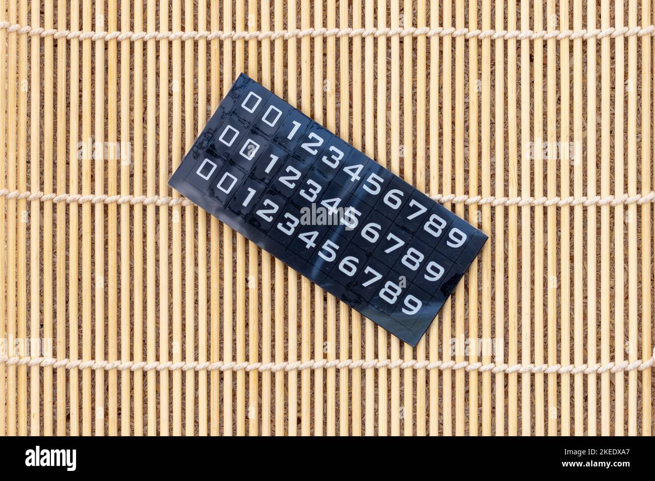 Plastic rubber sticker numbers from 0 to 9 list on a bamboo background ...