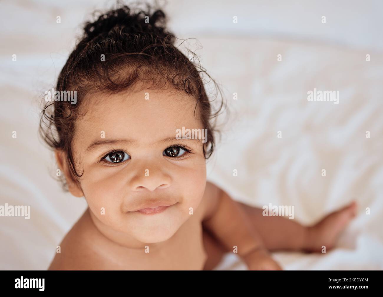 Face, baby and portrait with a newborn infant girl sitting in a cot or ...