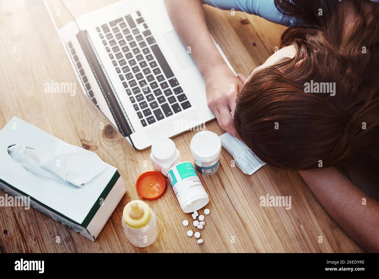 Feeling the strain. a young businesswoman trying to work while ...