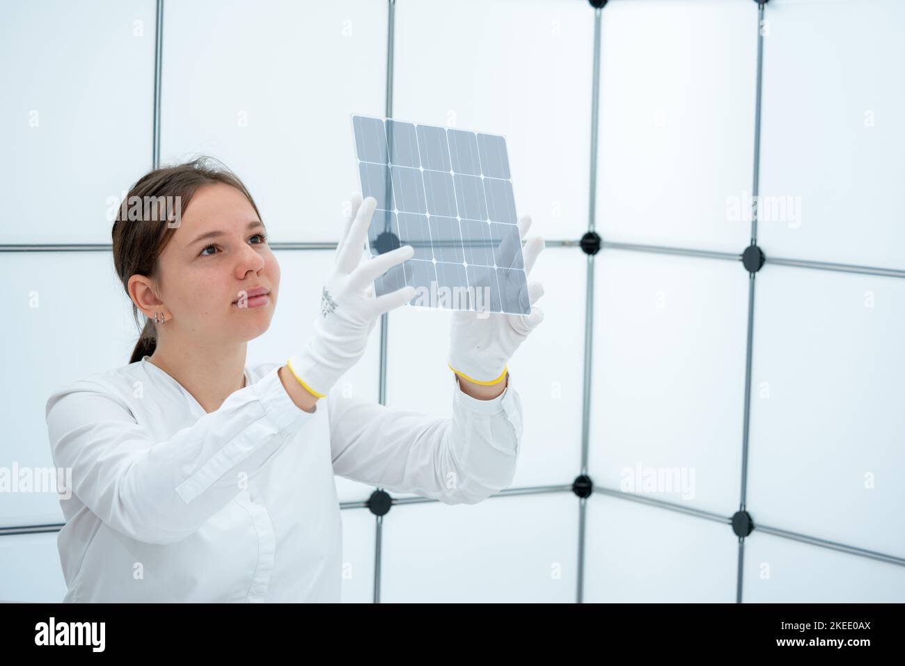 young woman controls a transparent solar battery element in a renewable ...