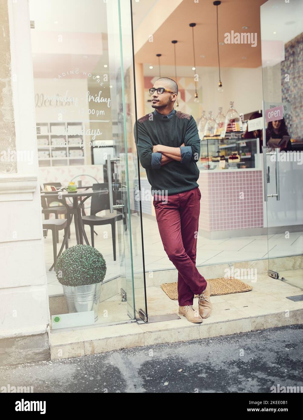 He has the coolest cafe in town. a young man standing in the entrance ...