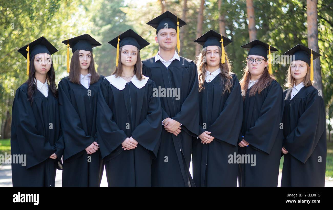 Seven graduates in robes stand in a row outdoors Stock Photo - Alamy