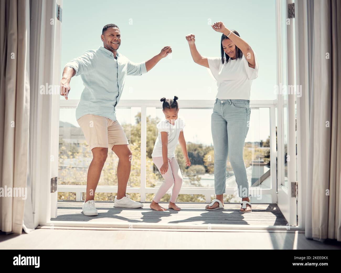 Family, dance and fun outside on house balcony for bonding, quality ...
