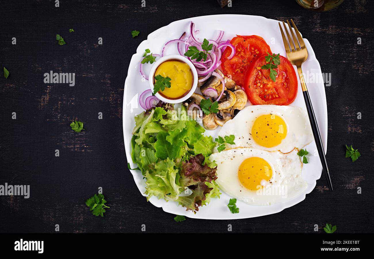Ketogenic food. Fried eggs, mushrooms and sliced tomatoes. Keto, paleo ...