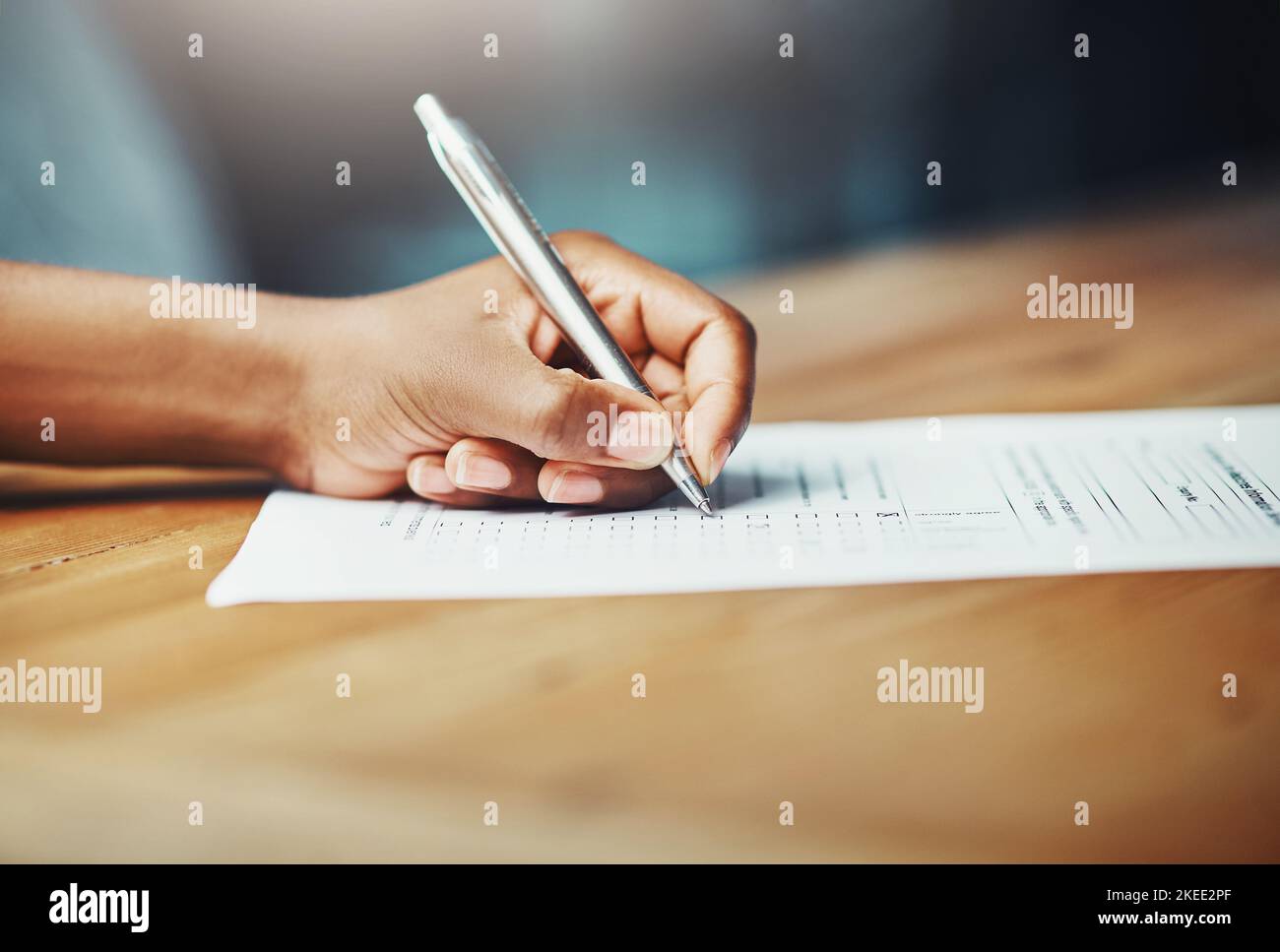 Making her mark. a woman filling in some paperwork at a desk Stock ...