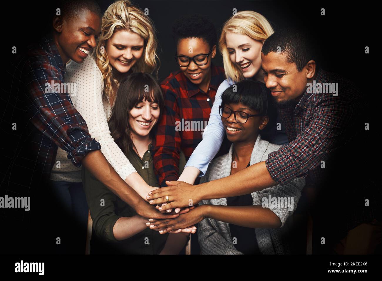 In it to win it. a group of cheerful work colleagues forming a huddle ...