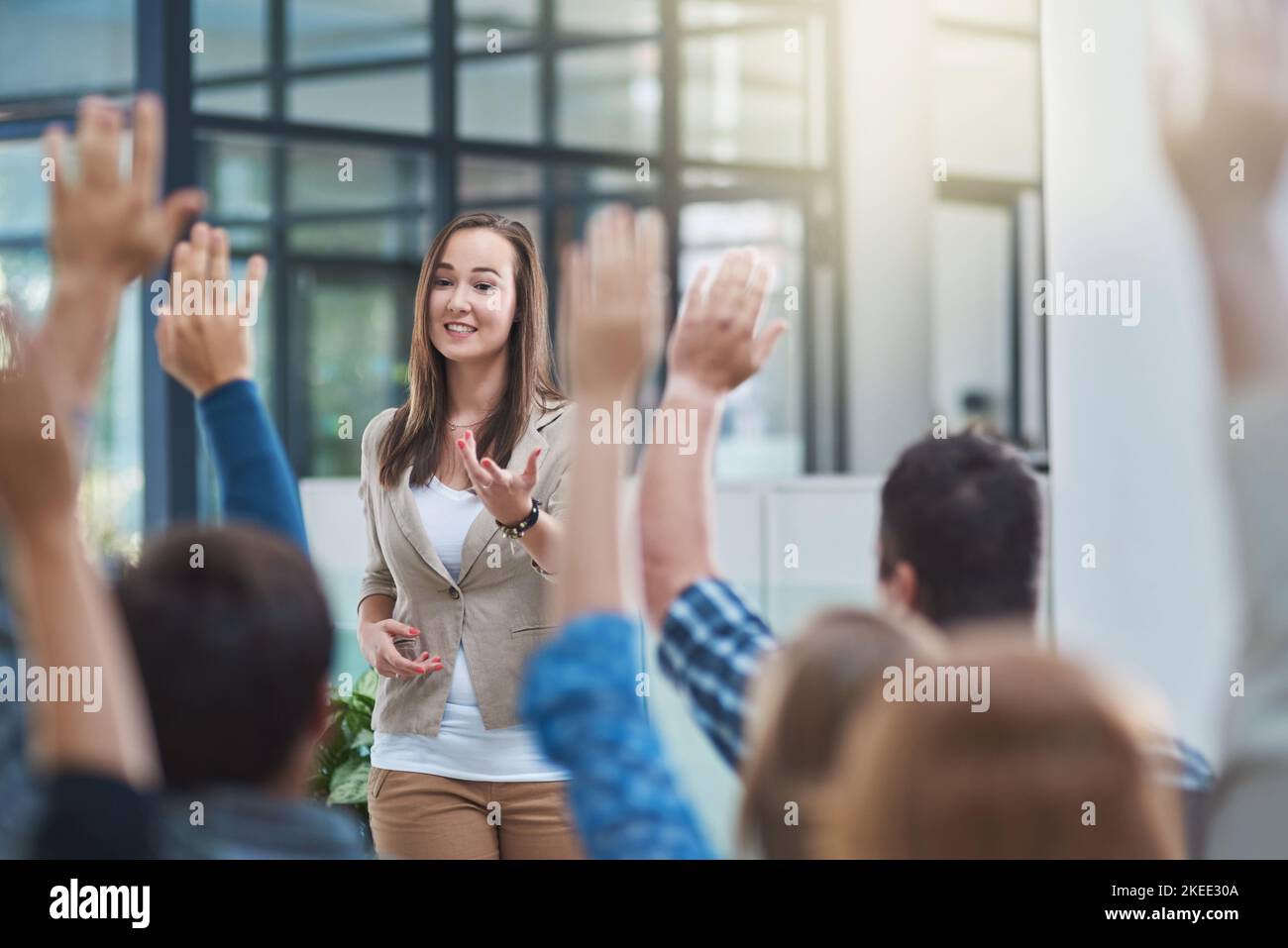 Ambitious to learn. a group of people raising their hands in a seminar ...