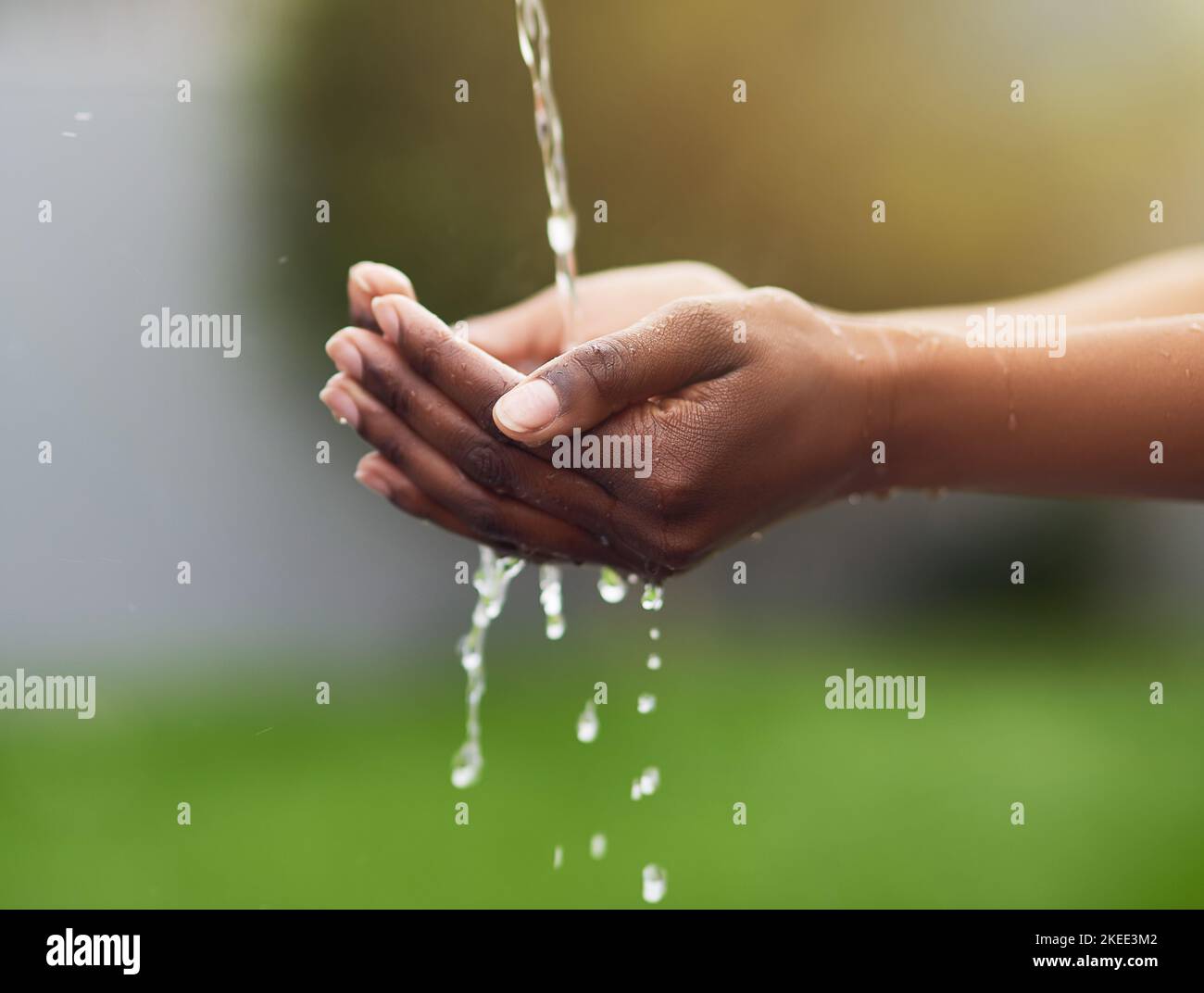 Save every last drop. a woman washing her hands outdoors Stock Photo ...