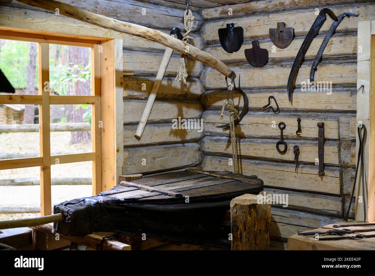 Fragment of a medieval blacksmith's workshop in a wooden hut with tools ...
