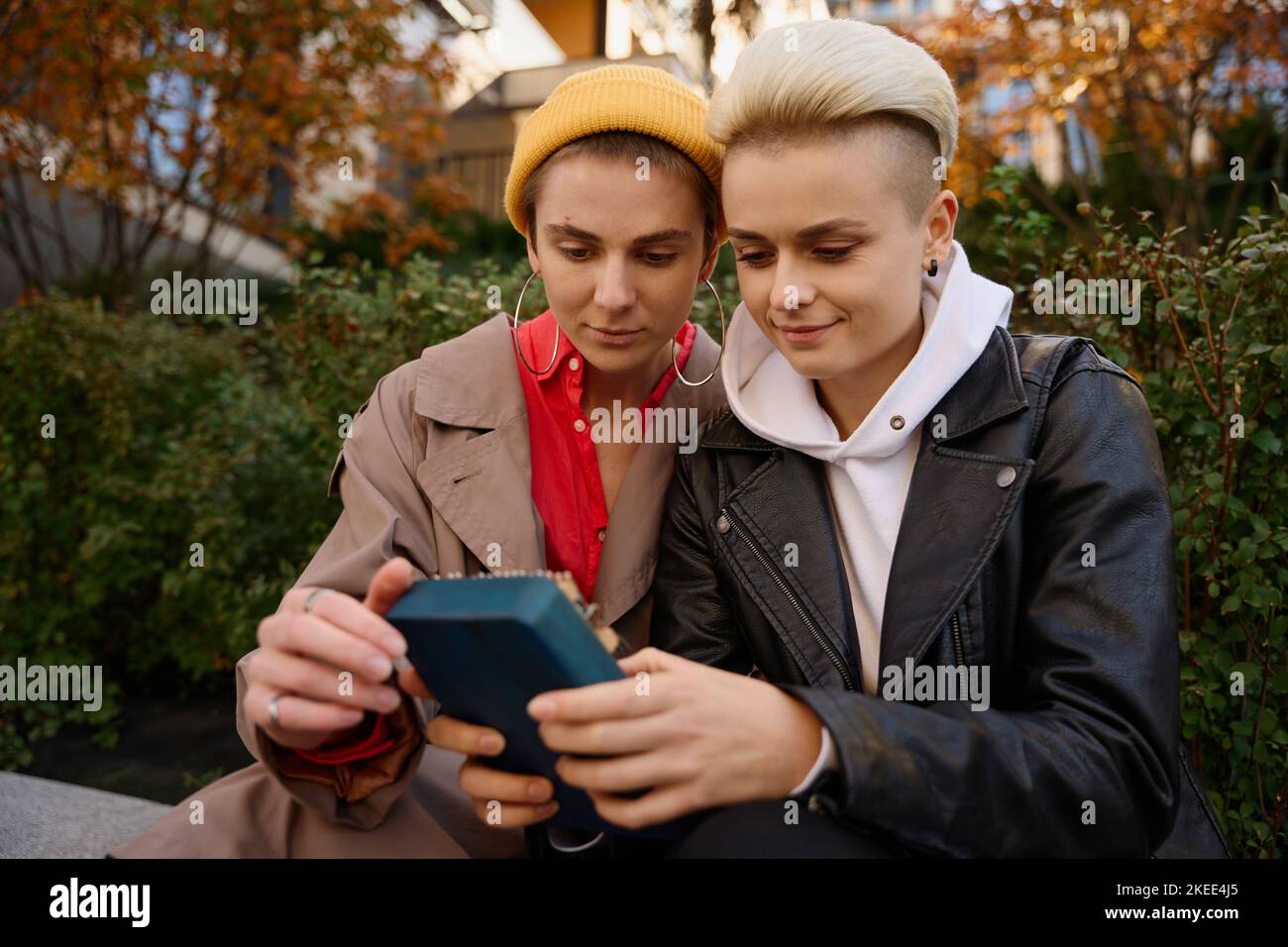 Young female LGBT couple is learning to play portable finger piano ...