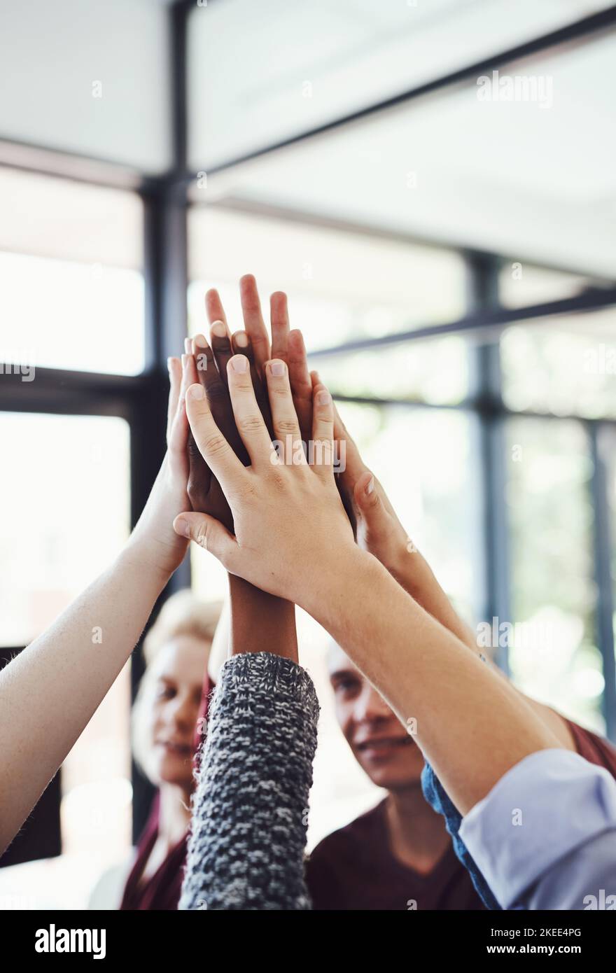 Heres to teamwork. a group of people high-fiving in the office Stock ...