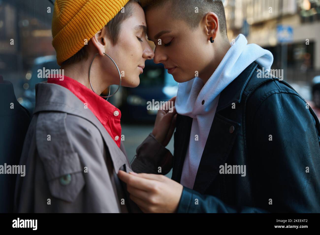 Two women in love stand near wall of large building Stock Photo - Alamy