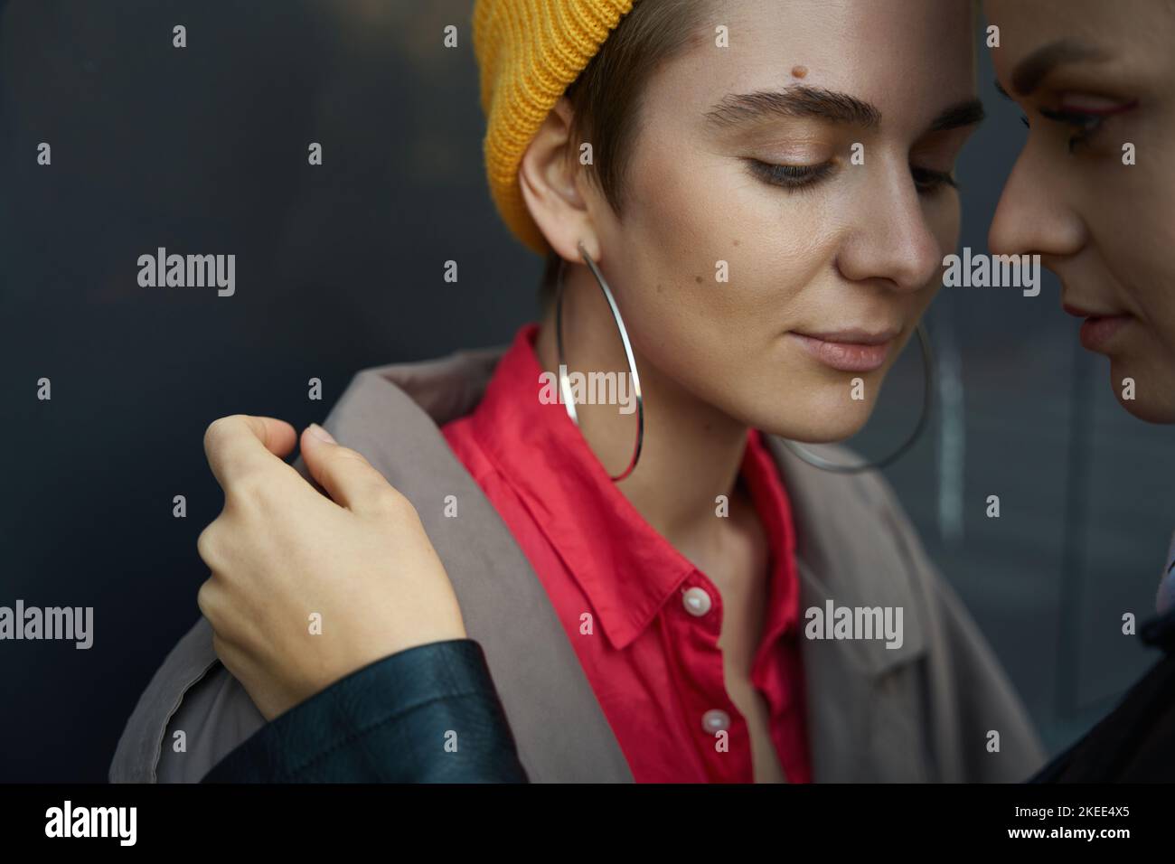 Women, LGBT couple, stand close to each other against gray wall Stock ...