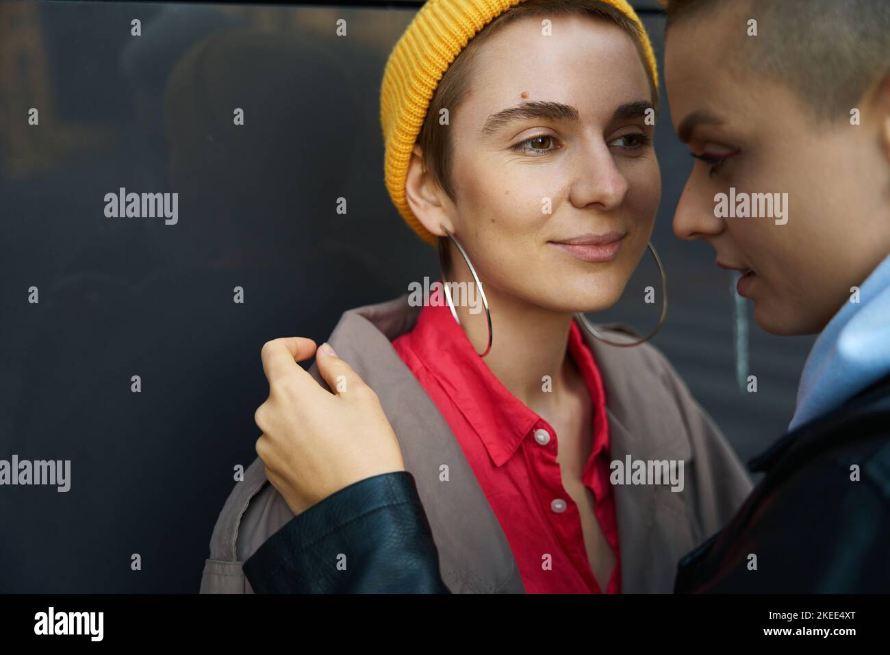 Women stand close to each other against a gray wall Stock Photo - Alamy