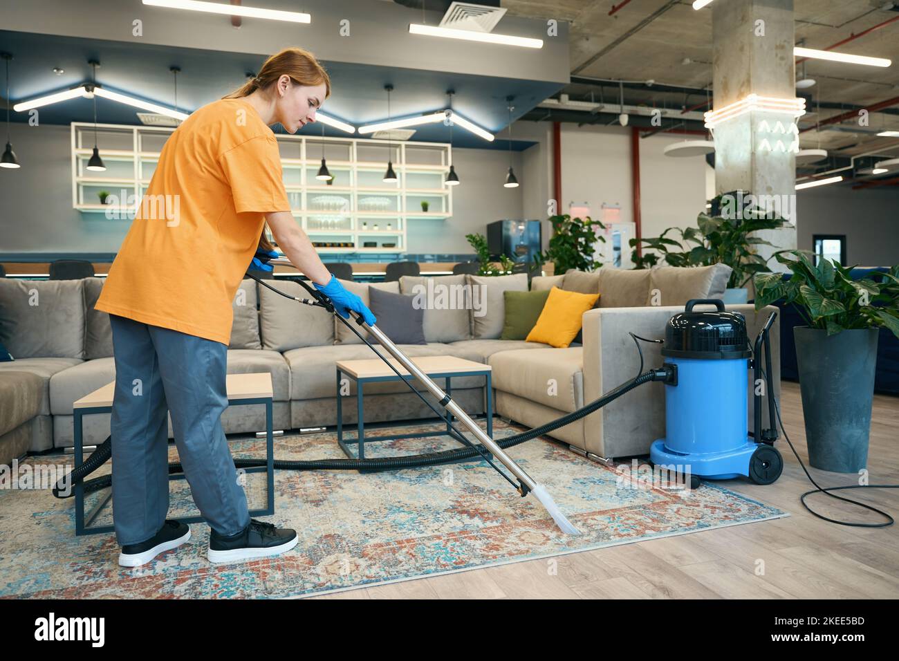 Cleaning company worker cleans a carpet in a recreation area Stock ...