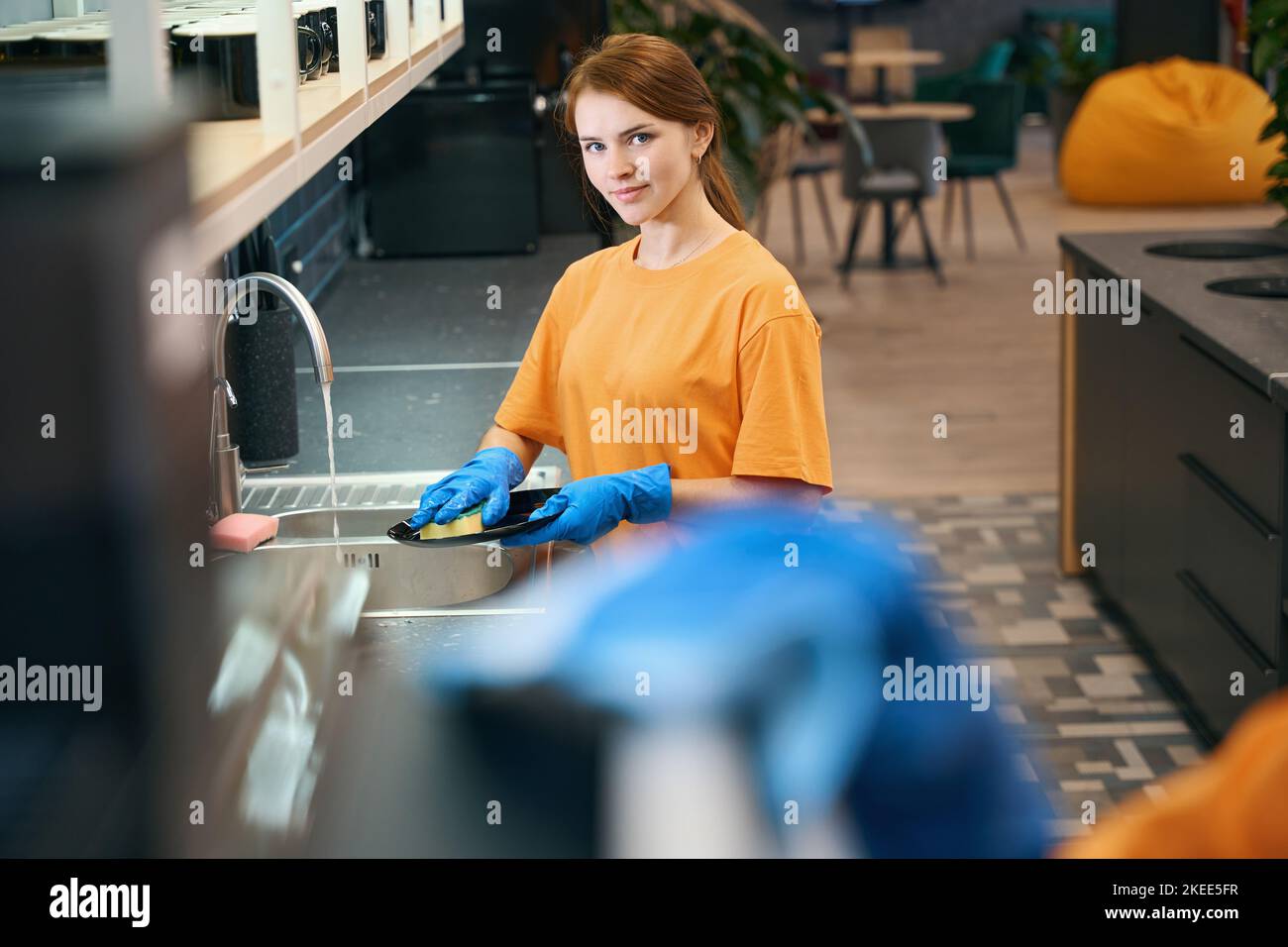 Woman cleaner washing dishes in the kitchen area Stock Photo - Alamy