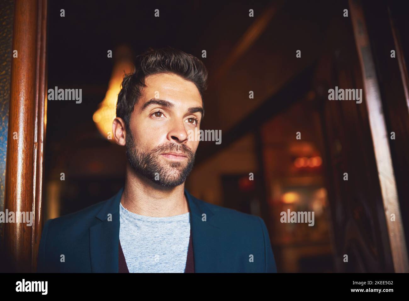 Frequenting his favourite bar. a young man standing in a bar Stock ...