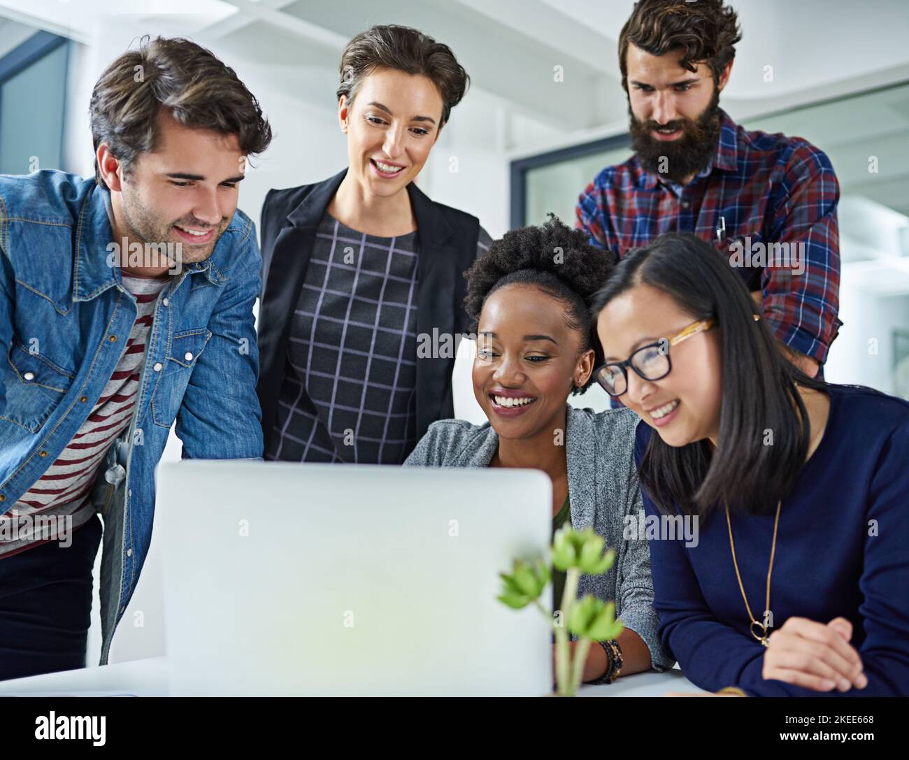 Making ideas happen together. colleagues working together on a laptop ...