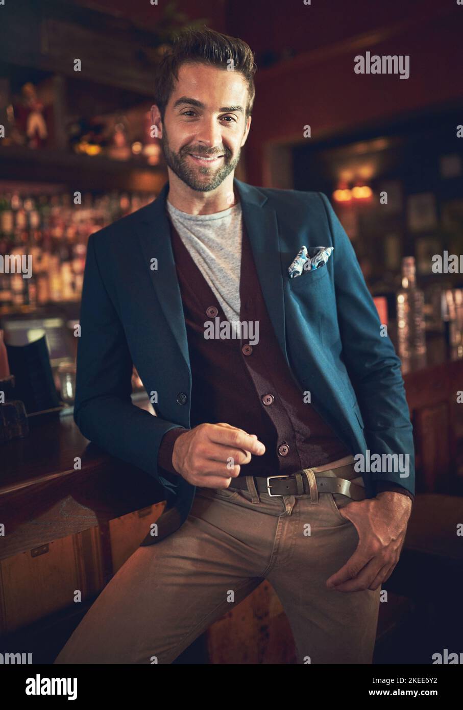 Pull up a chair. Cropped portrait of a young man standing in a bar ...