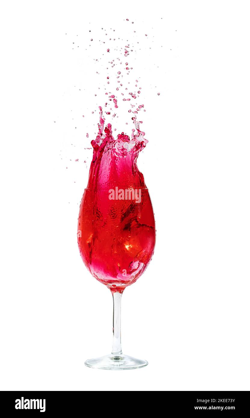A red drink spurt out from a glass, isolated on a white background ...