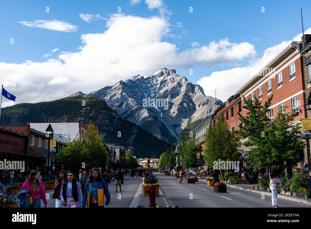 The crowded main city of Banff town with rocky mountain peak and blue ...