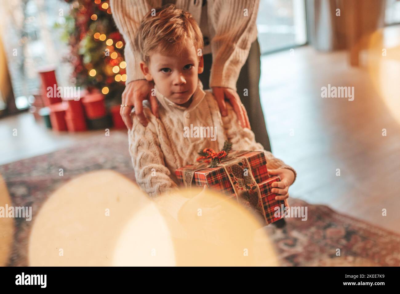 Portrait of happy family mom with small son in knitted beige sweaters ...