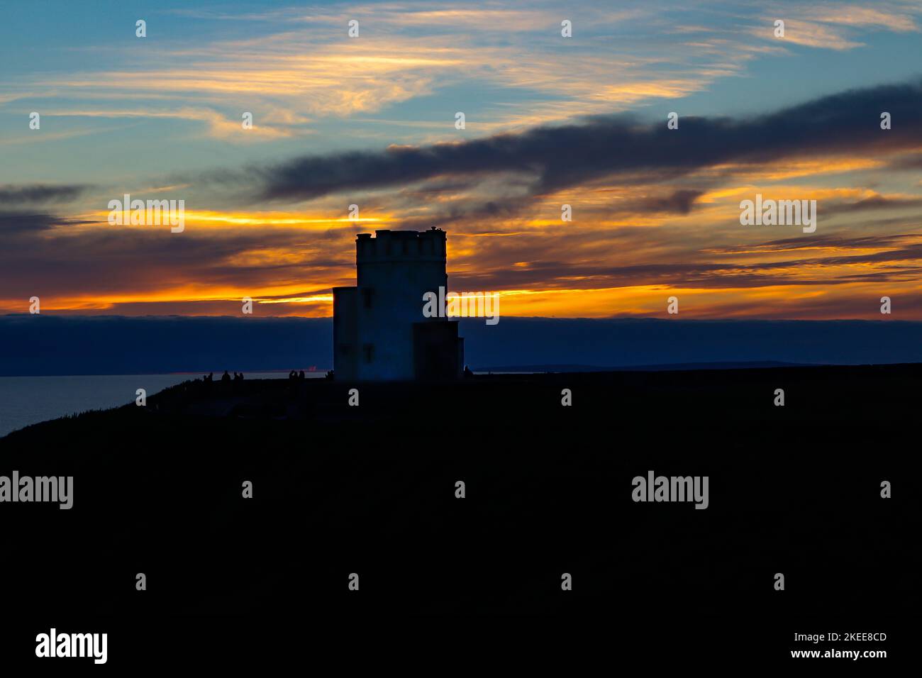 A beautiful sunset over the silhouette of a medieval tower Stock Photo ...