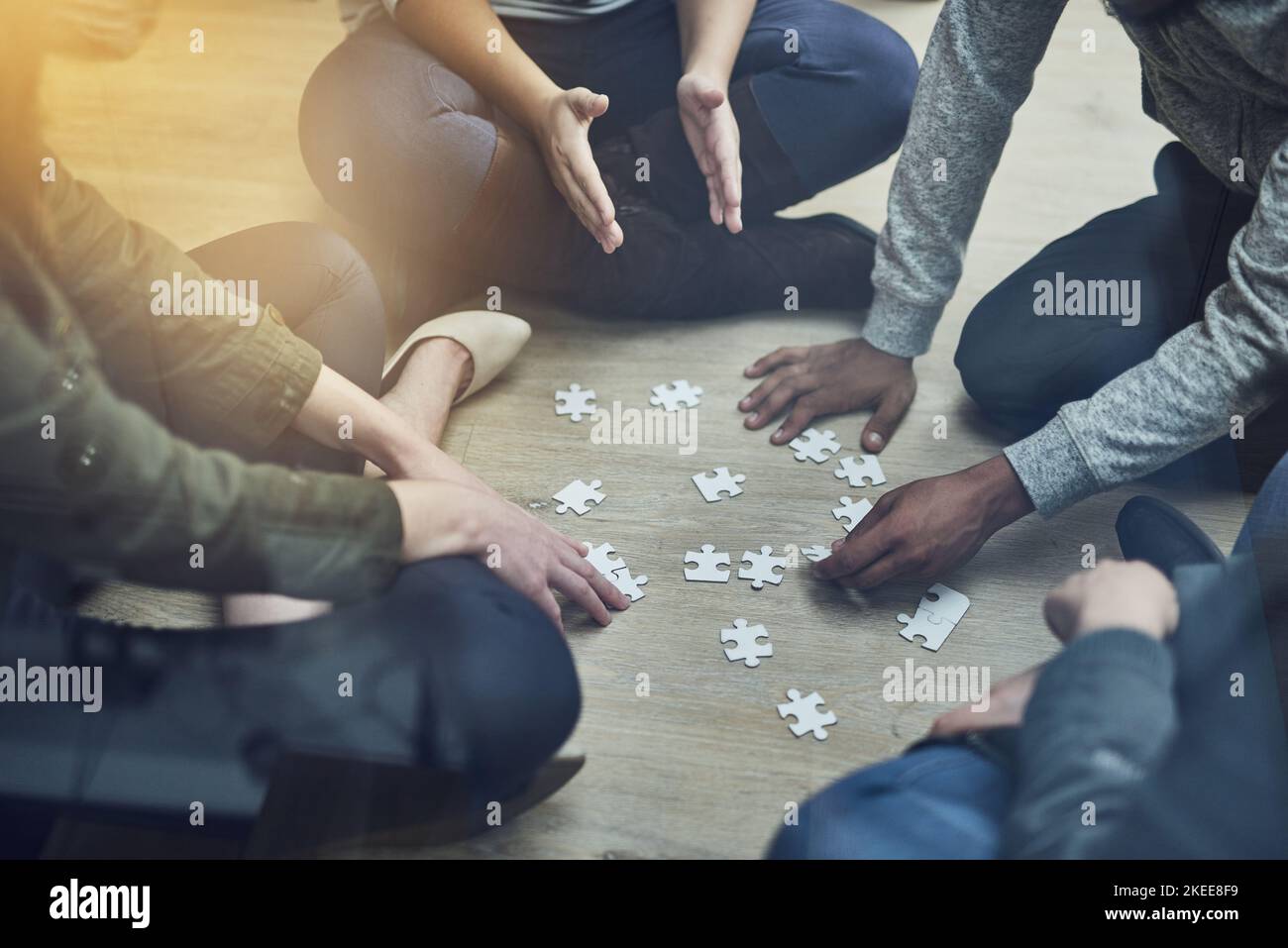 Progressing as a team to solve the puzzle. a group of people building a ...