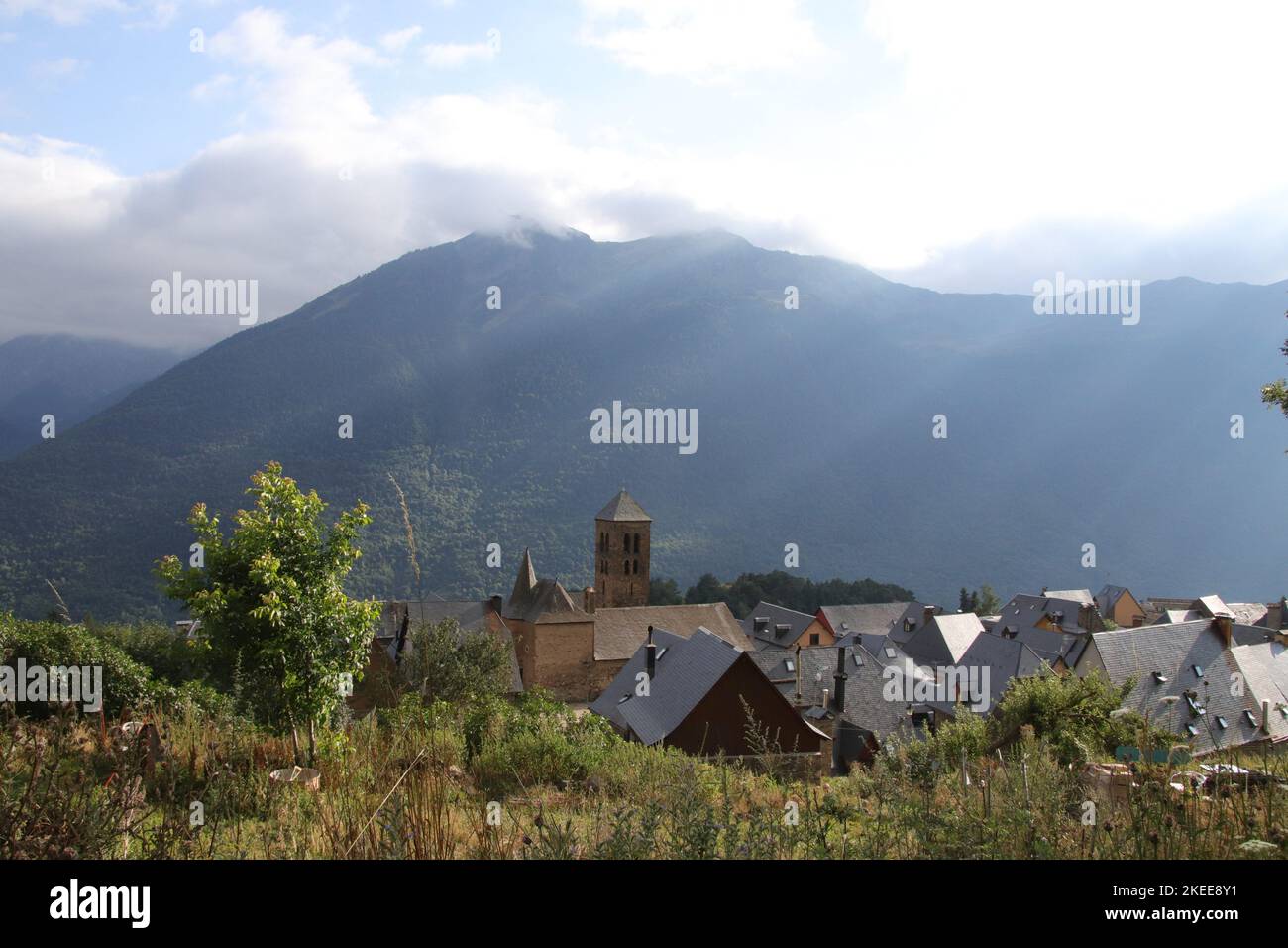 A high-angle of Vilamos in Aran valley with misty, sunlit Pyrenees ...