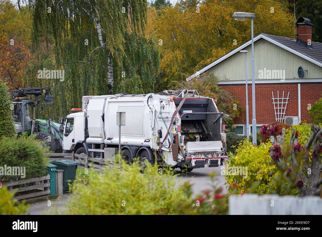 garbage collection service dump truck on the street with residential ...