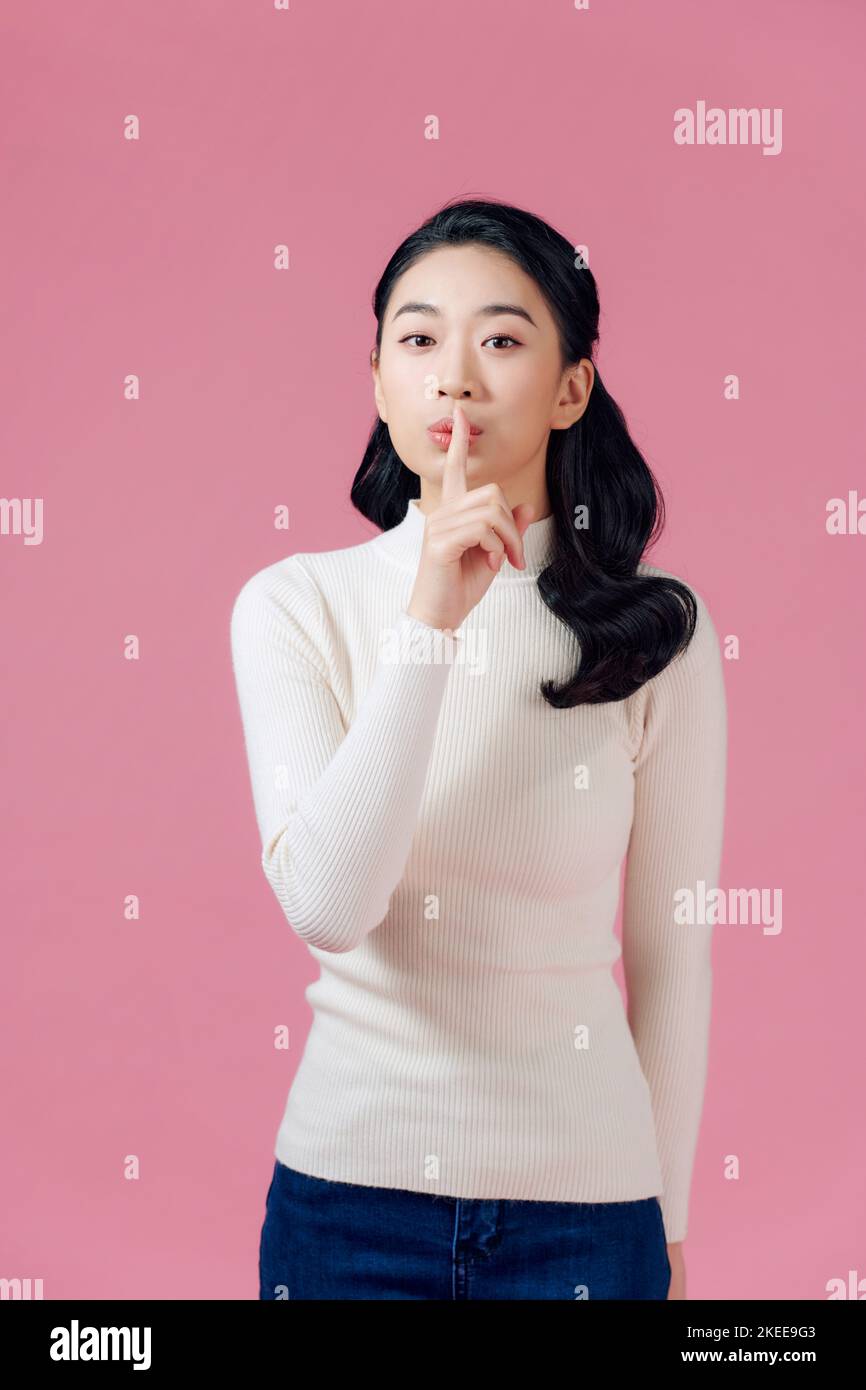 Asian woman saying hush be quiet Stock Photo - Alamy