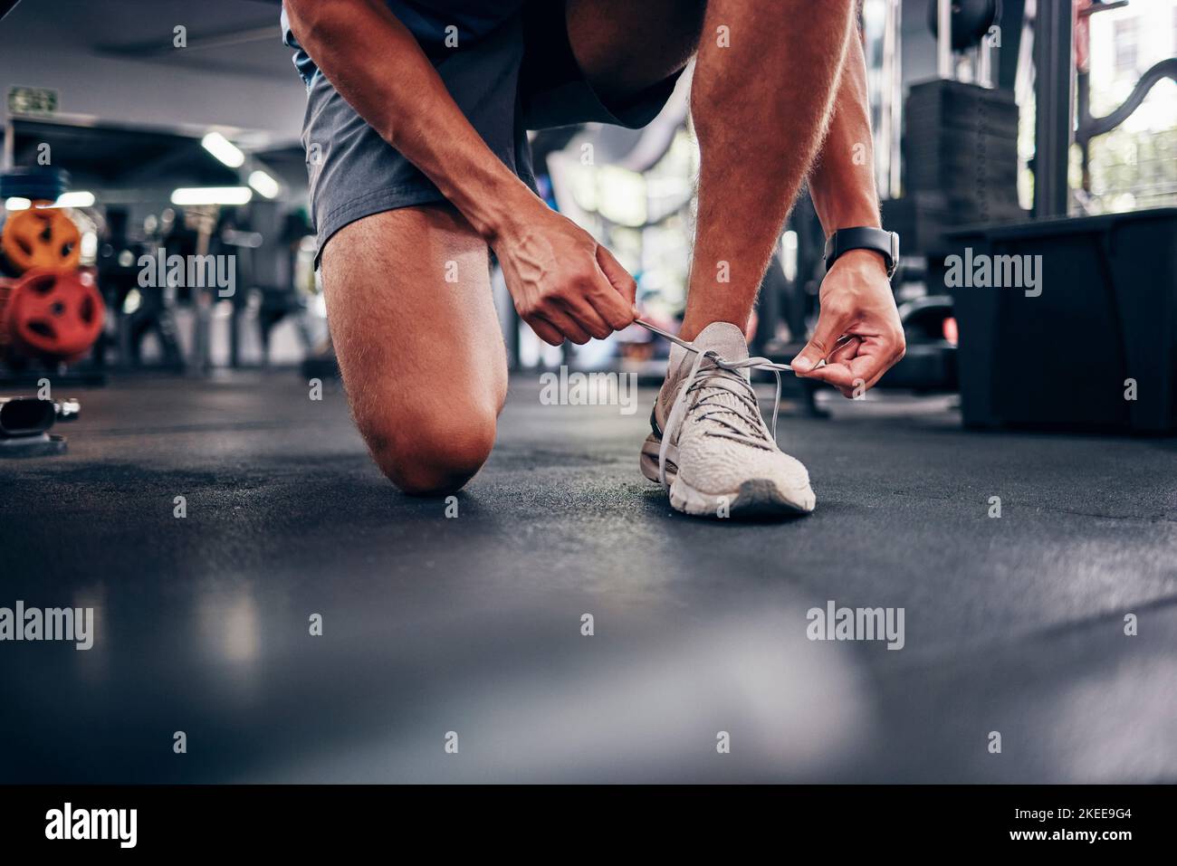 Hands, gym and man tie shoes preparing for training, running or exercise. Sports, fitness or ...