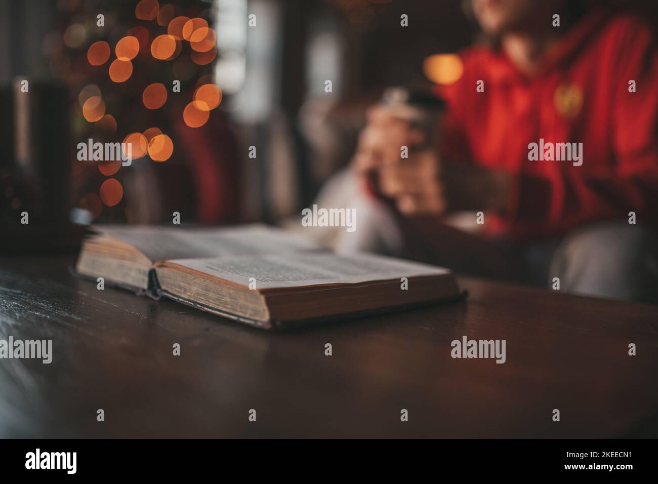 Young teen boy with long hair holding and reading study book for ...
